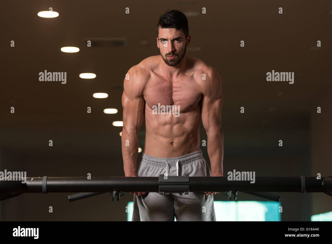 Young Bodybuilder Doing Dips on Bar Exercising Triceps On Machine In ...