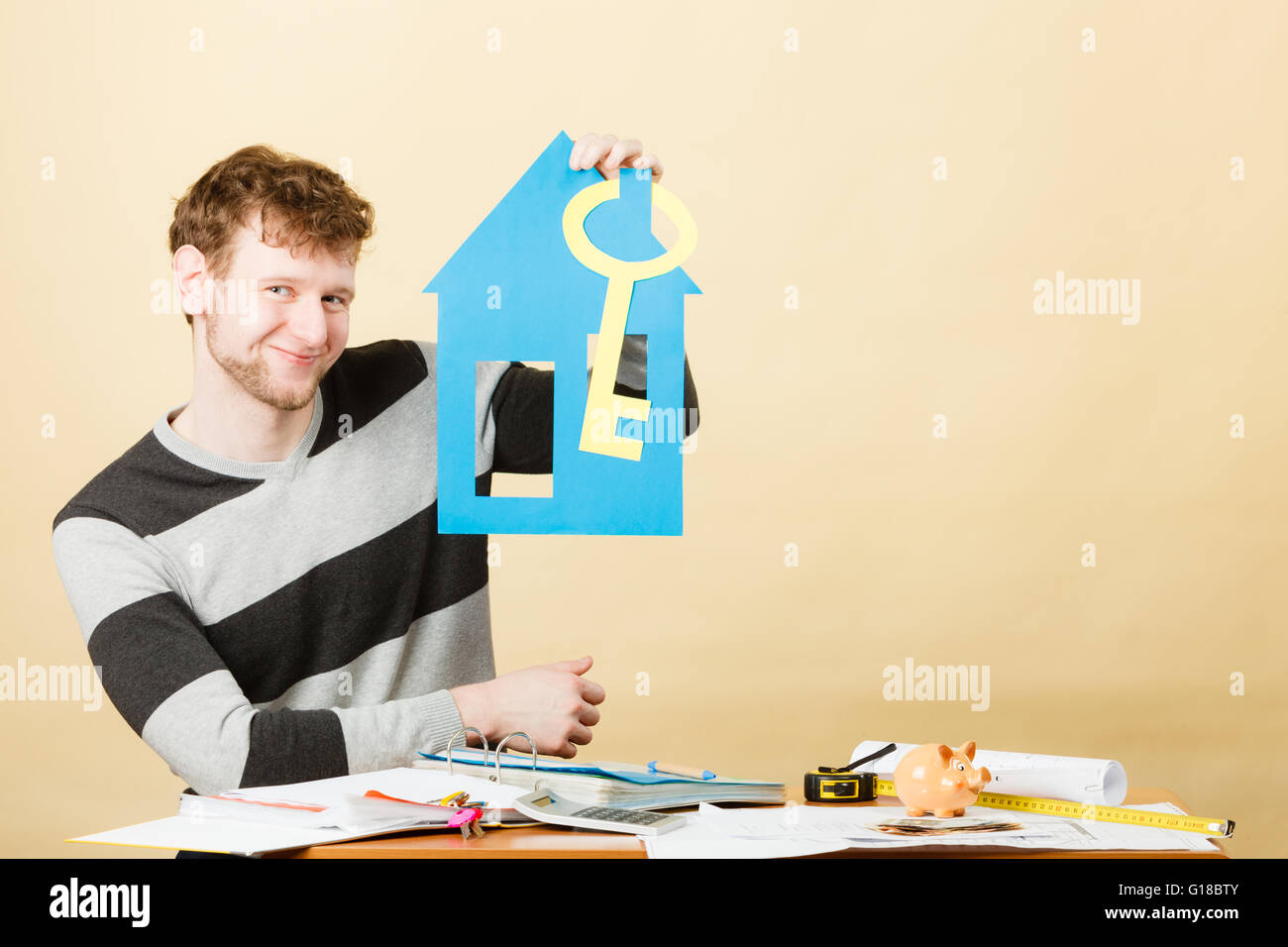 Good purchase concept. Male buyer with paper model of house and key ...