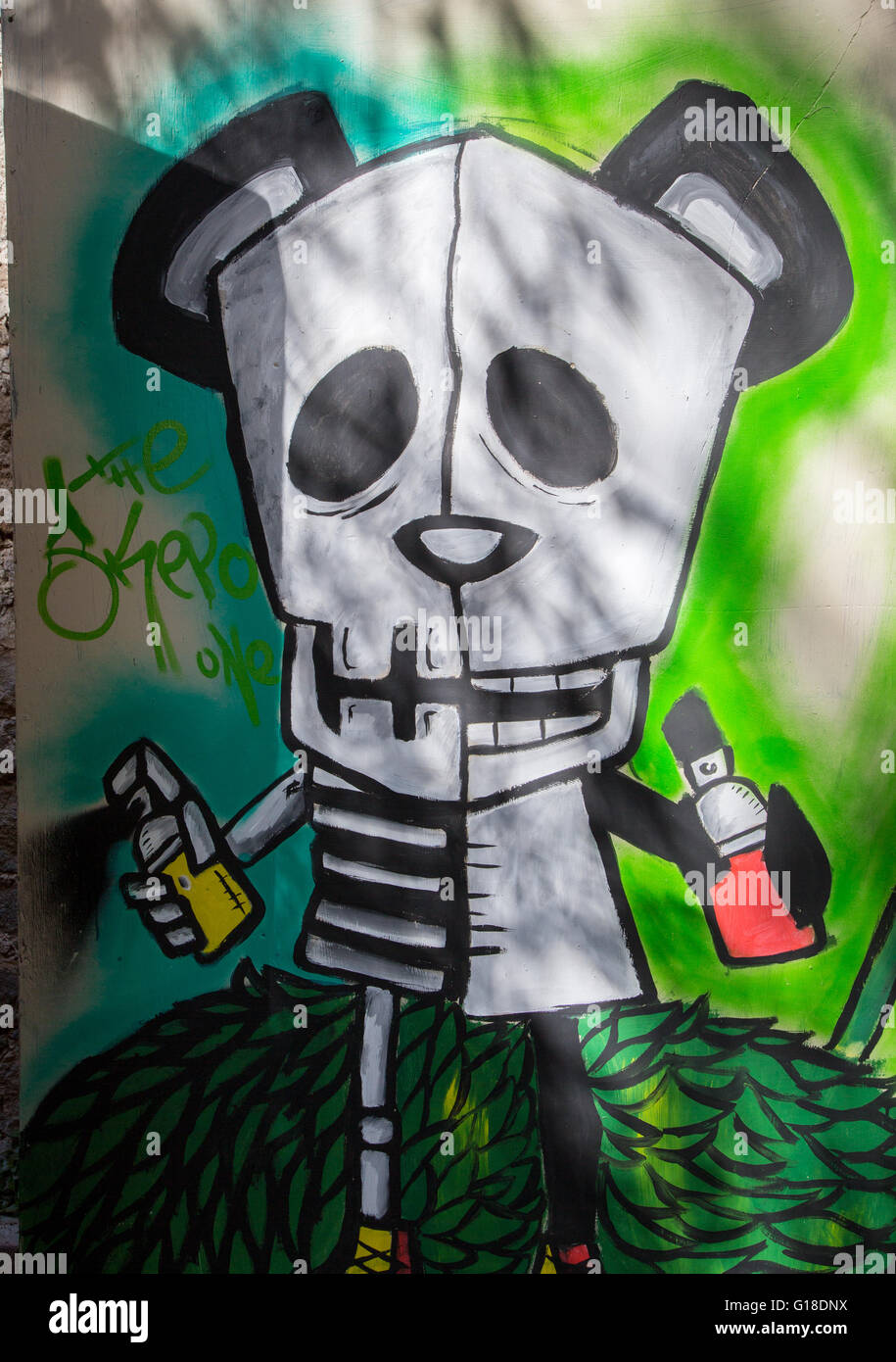 Urban art depicting a skeleton person with spray paints in city of ...