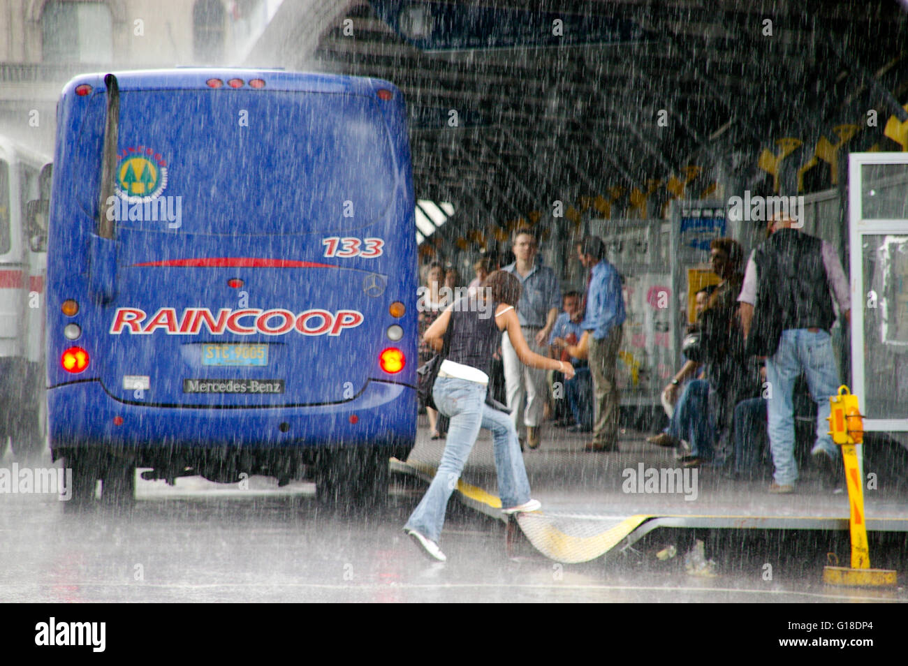 Woman in pouring rain at bus station Stock Photo - Alamy