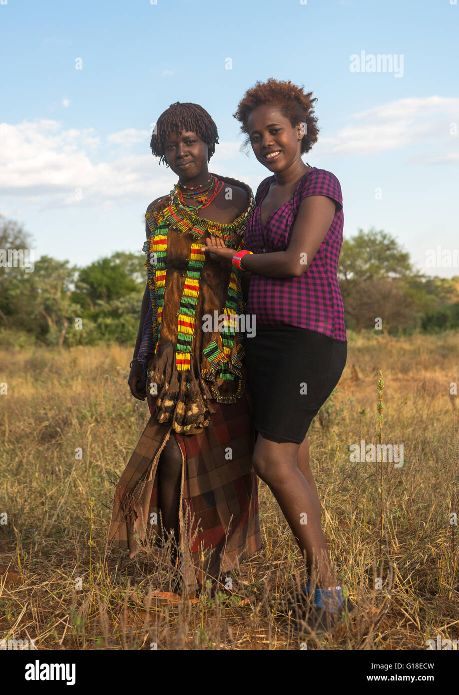 Hamer tribe woman with a hamer friend in western clothes attending a ...