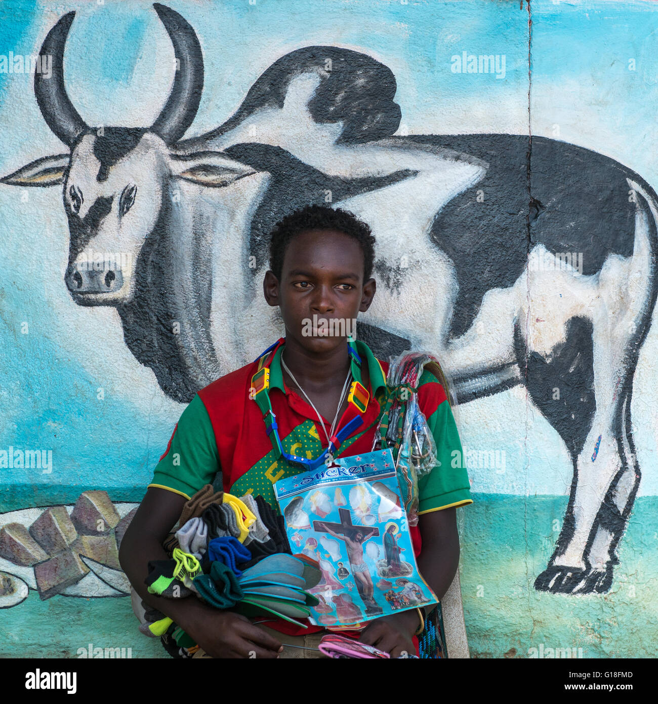 Ethiopian teenage boy in front of a mural decpicting a zebu, Omo valley, Jinka, Ethiopia Stock ...