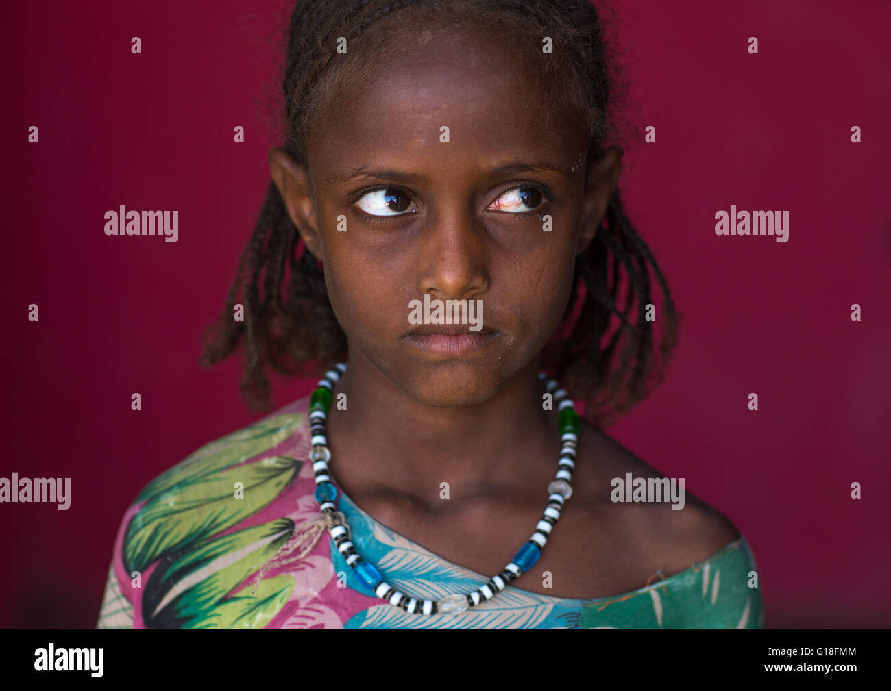 Portrait of an afar tribe girl on a red background, Afar region, Semera ...