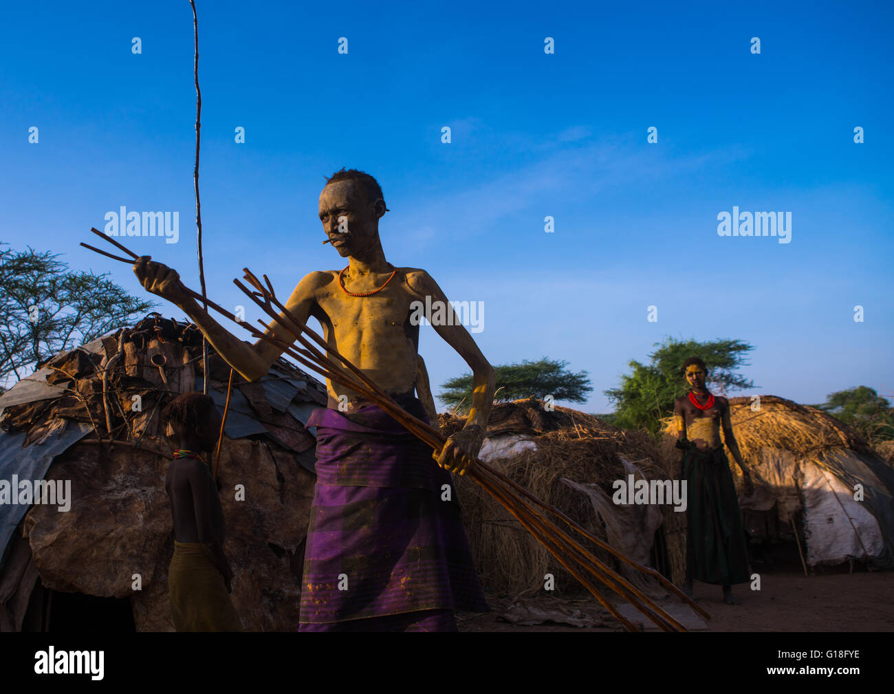 Dassanech man preparing the long sticks for dimi ceremony to celebrate ...