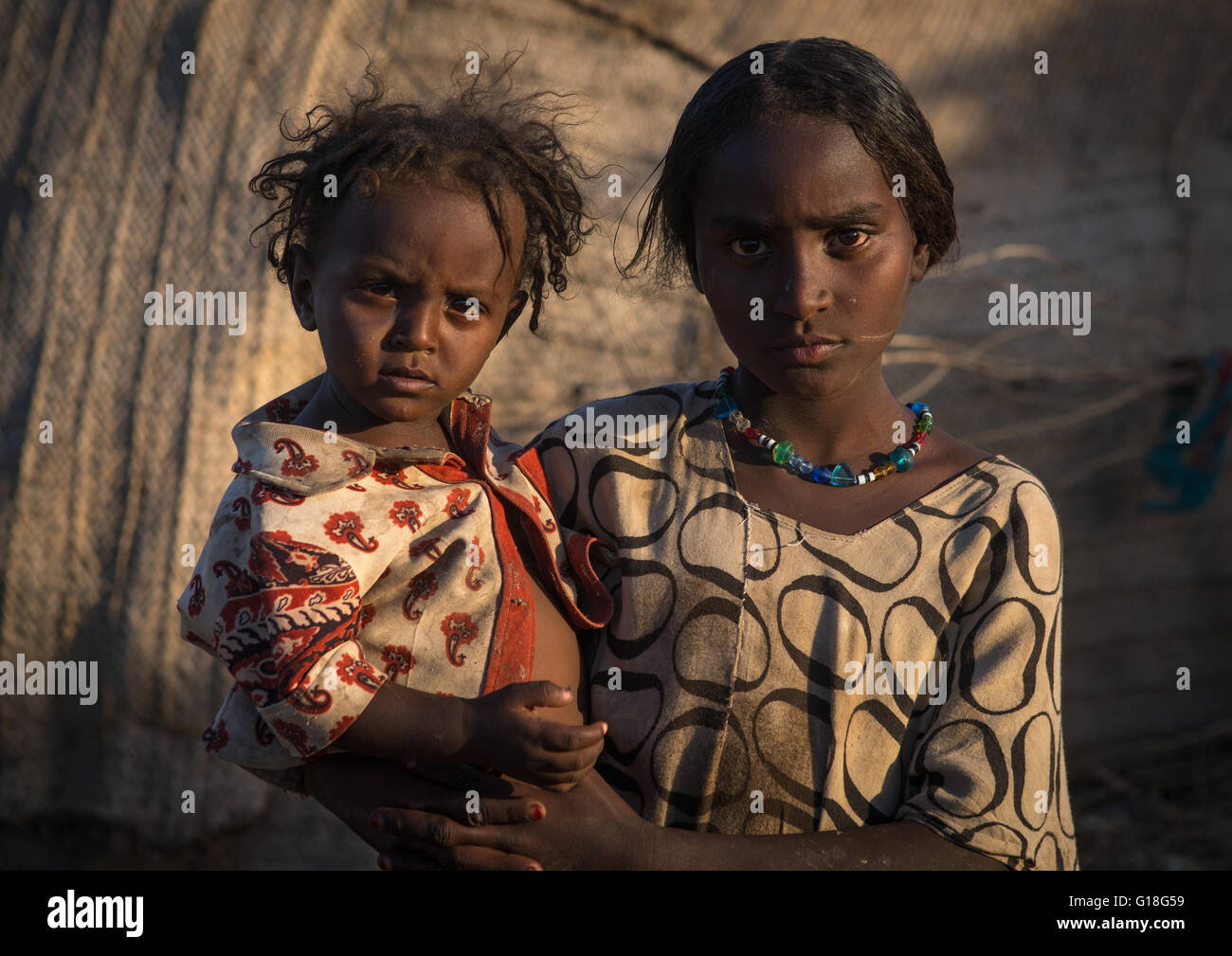 Portrait of an afar tribe teenage girl with a todder, Afar region ...