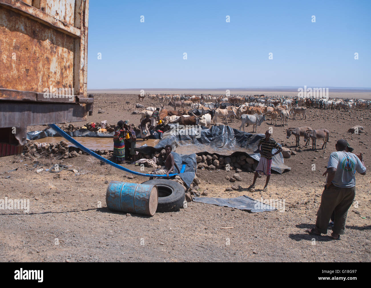 Somali people collecting water in a tank in the desert, Afar region ...