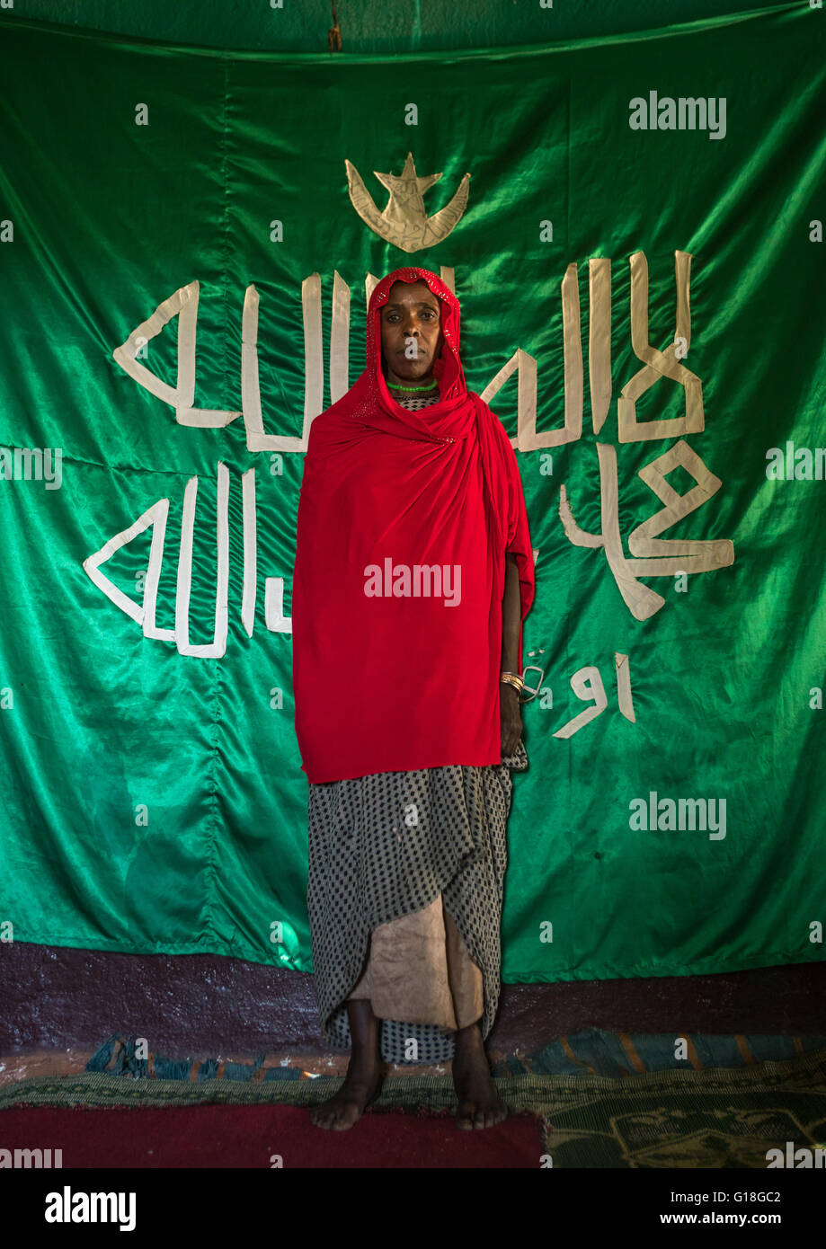 Sufi woman worshipper in front of islamic green flag, Harari region ...