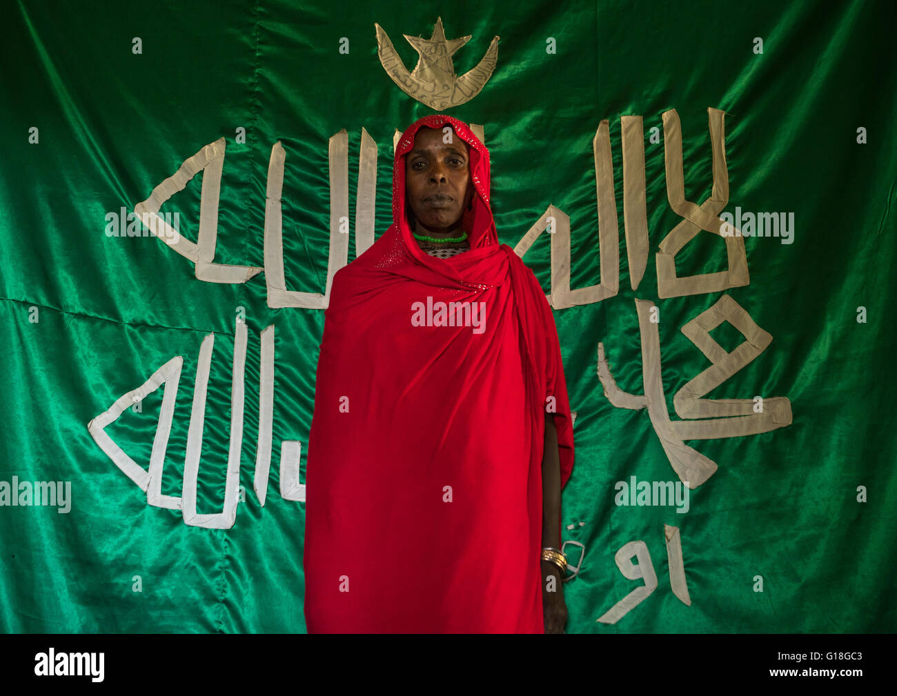 Sufi woman worshipper in front of islamic green flag, Harari region ...