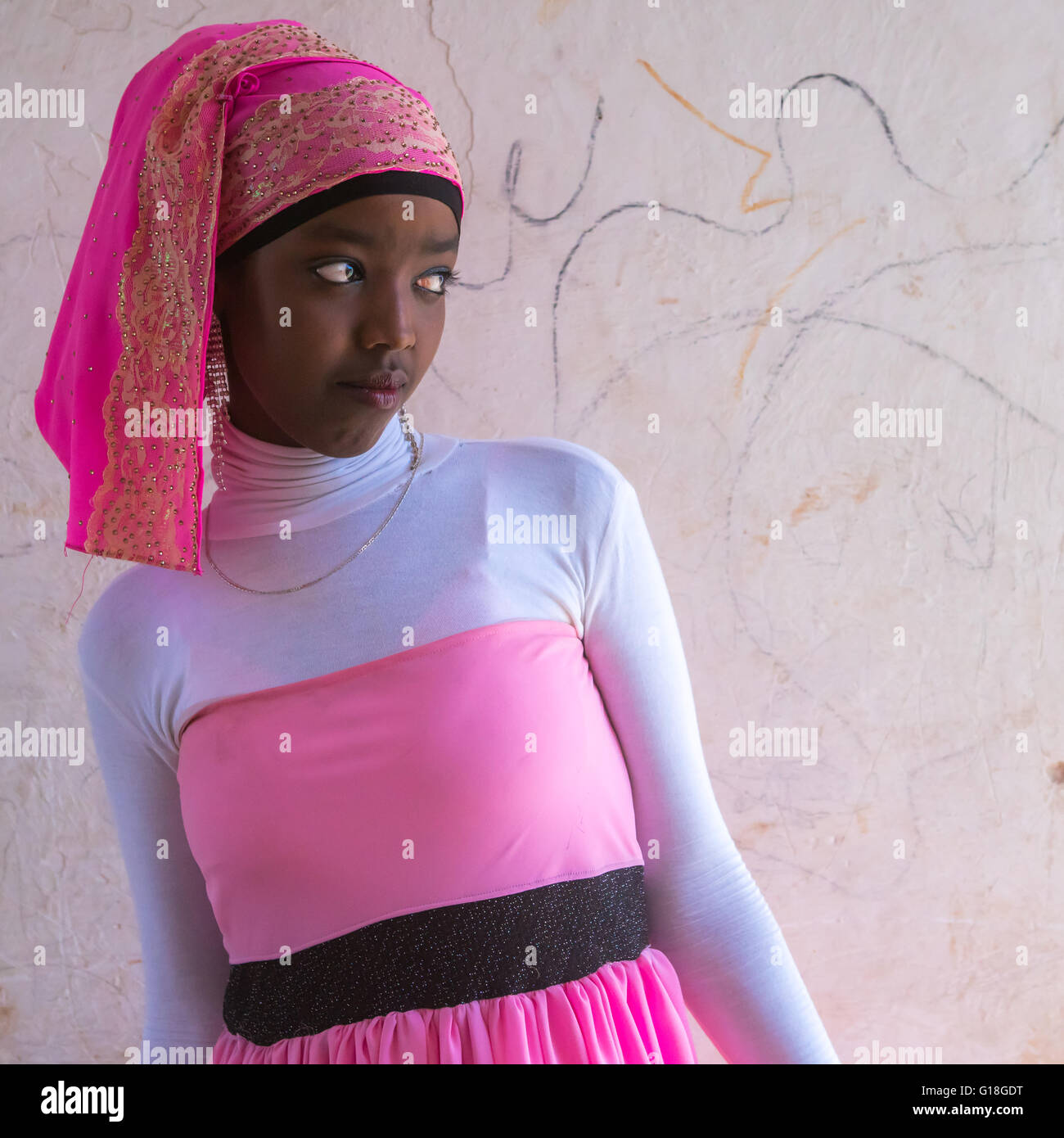 Beautiful teenage girl in pink in the street of the old town, Harari ...