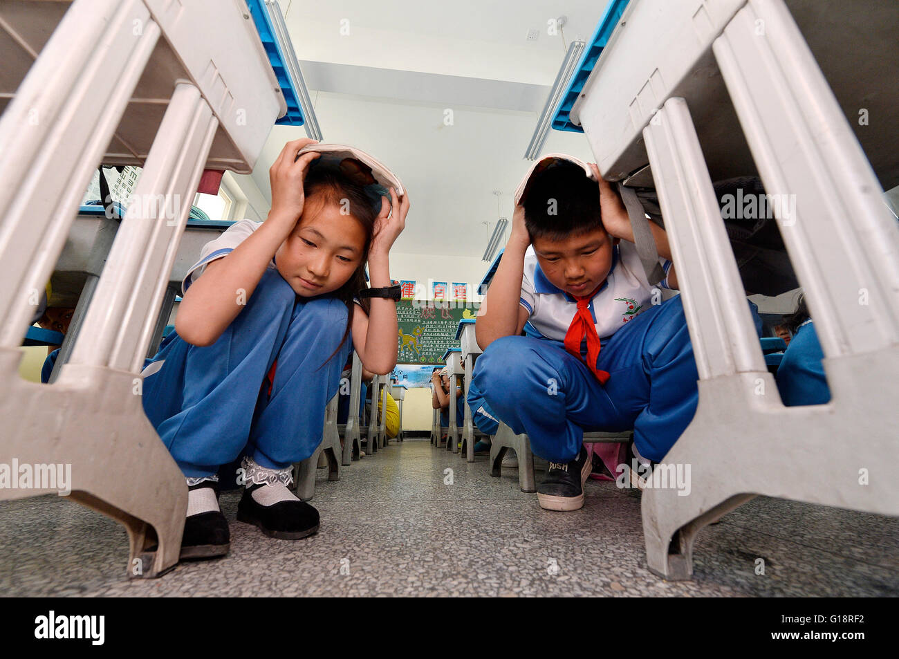 Yinchuan. 11th May, 2016. Students hide themselves under desks at the ...
