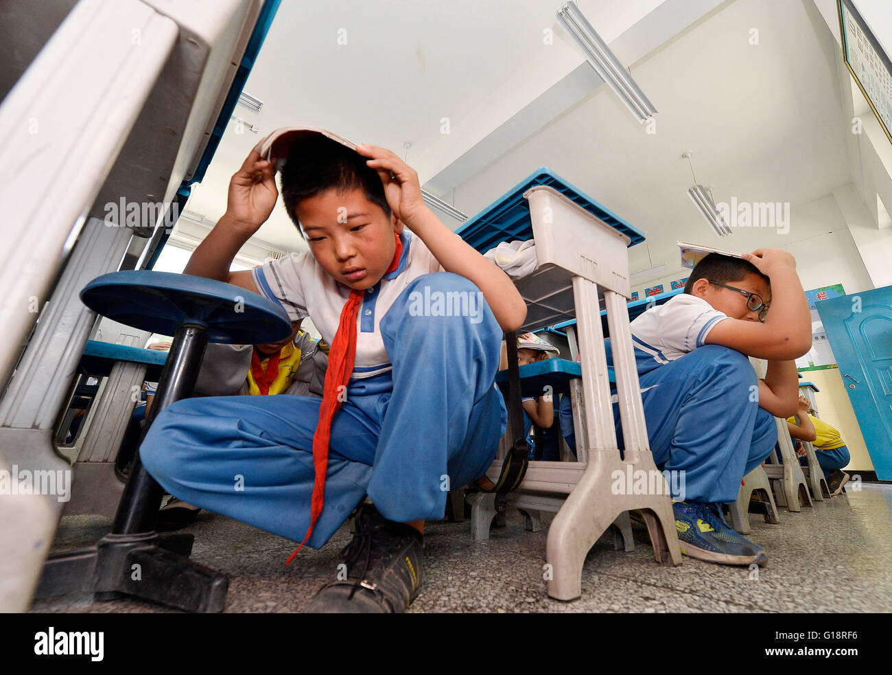 Yinchuan. 11th May, 2016. Students hide themselves under desks at the ...