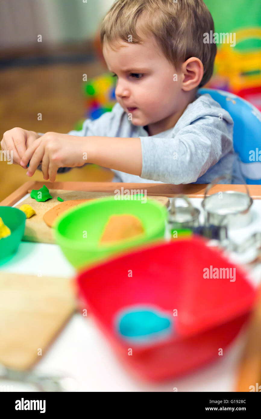 Little boy being creative with playdough Stock Photo - Alamy