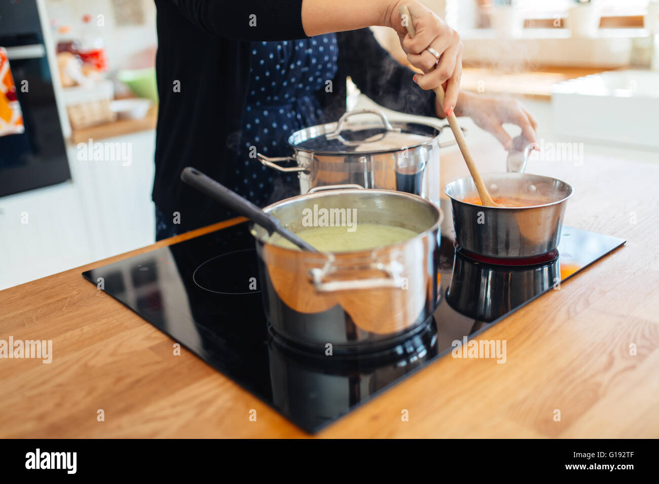 Woman making lunch in kitchen and stirring soup Stock Photo - Alamy