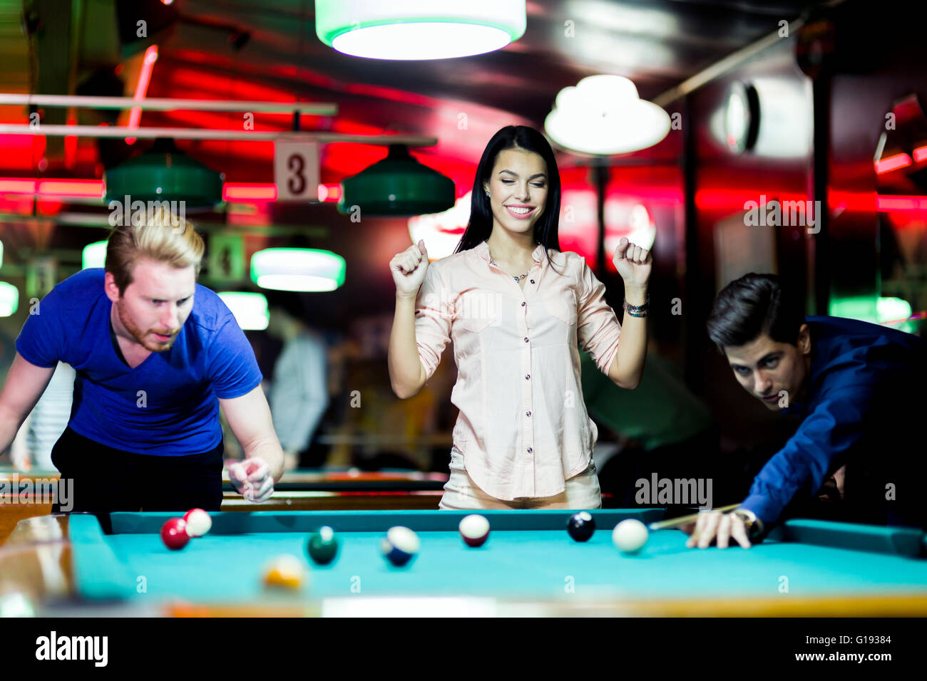 Young people playing billiard in a club pub bar Stock Photo - Alamy