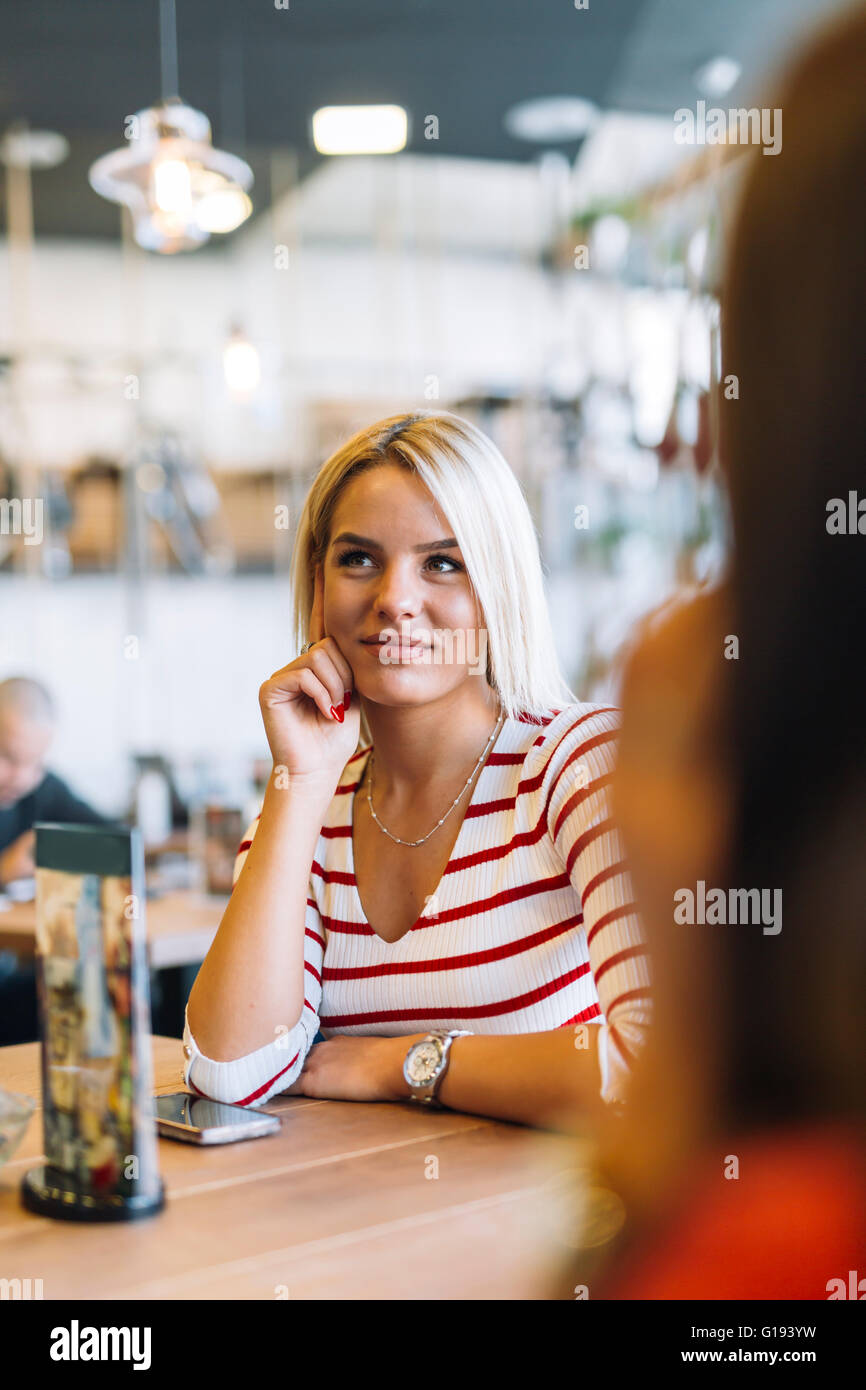Beautiful women in cafe talking and gossiping Stock Photo - Alamy