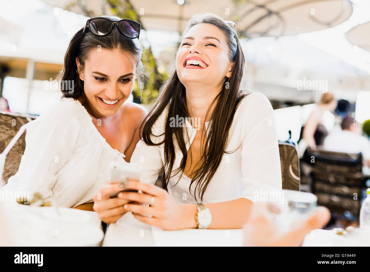 Two young girls talking and smiling during lunch break Stock Photo - Alamy