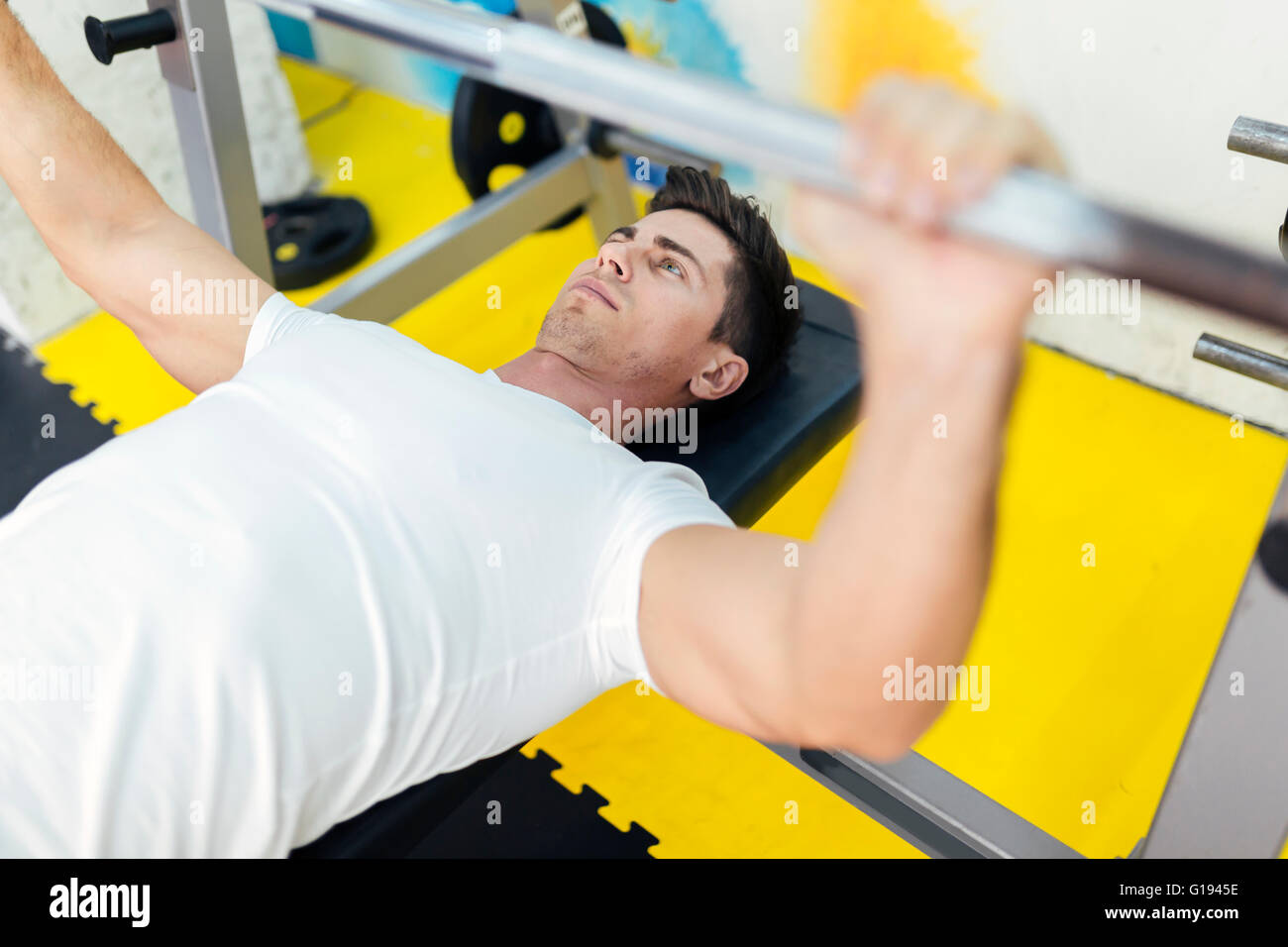Handsome man lifting weights in gym and staying fit Stock Photo - Alamy
