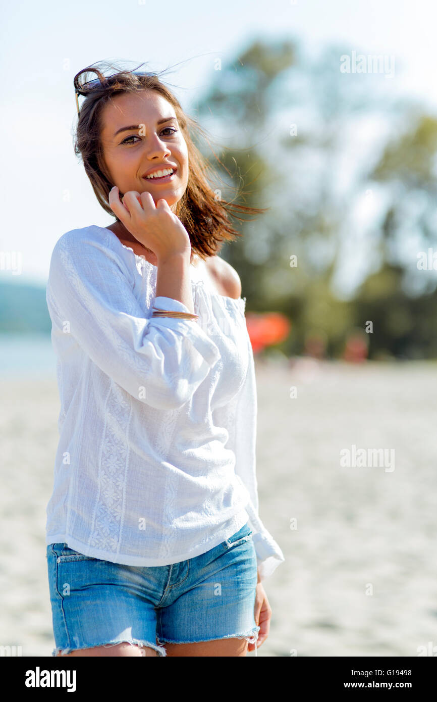Beautiful young woman posing on a windy summer day on the beach Stock ...
