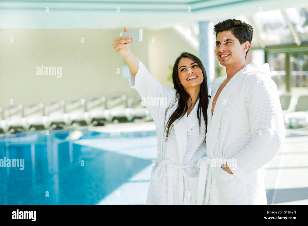 Couple in love standing next to a pool in a robe and relaxing Stock ...