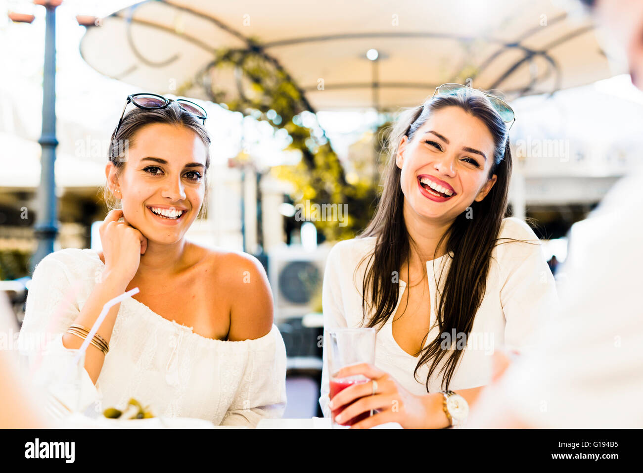 Two young girls talking and smiling during lunch break Stock Photo - Alamy
