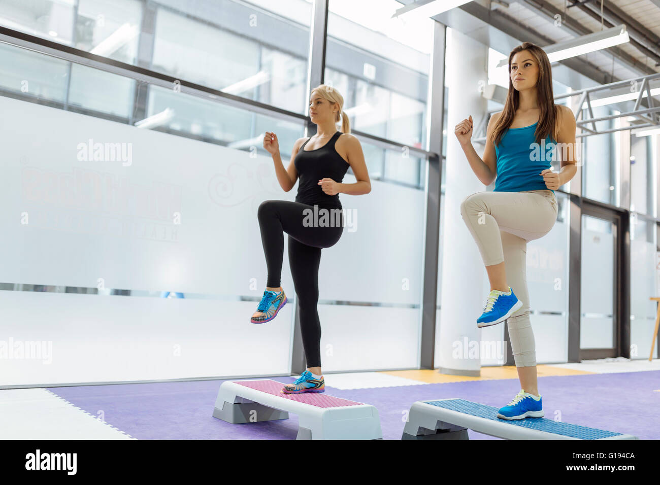 Beautiful women exercising aerobics in nice fitness club Stock Photo ...
