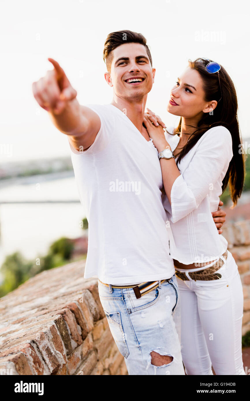 Happy couple pointing in a direction and smiling Stock Photo - Alamy