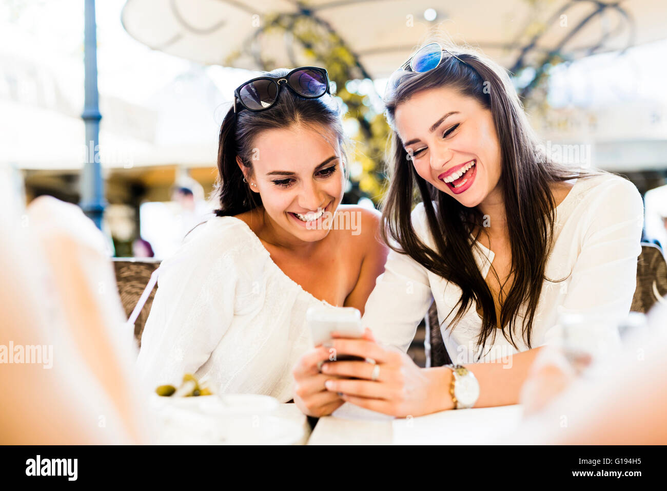 Two young girls talking and smiling during lunch break Stock Photo - Alamy