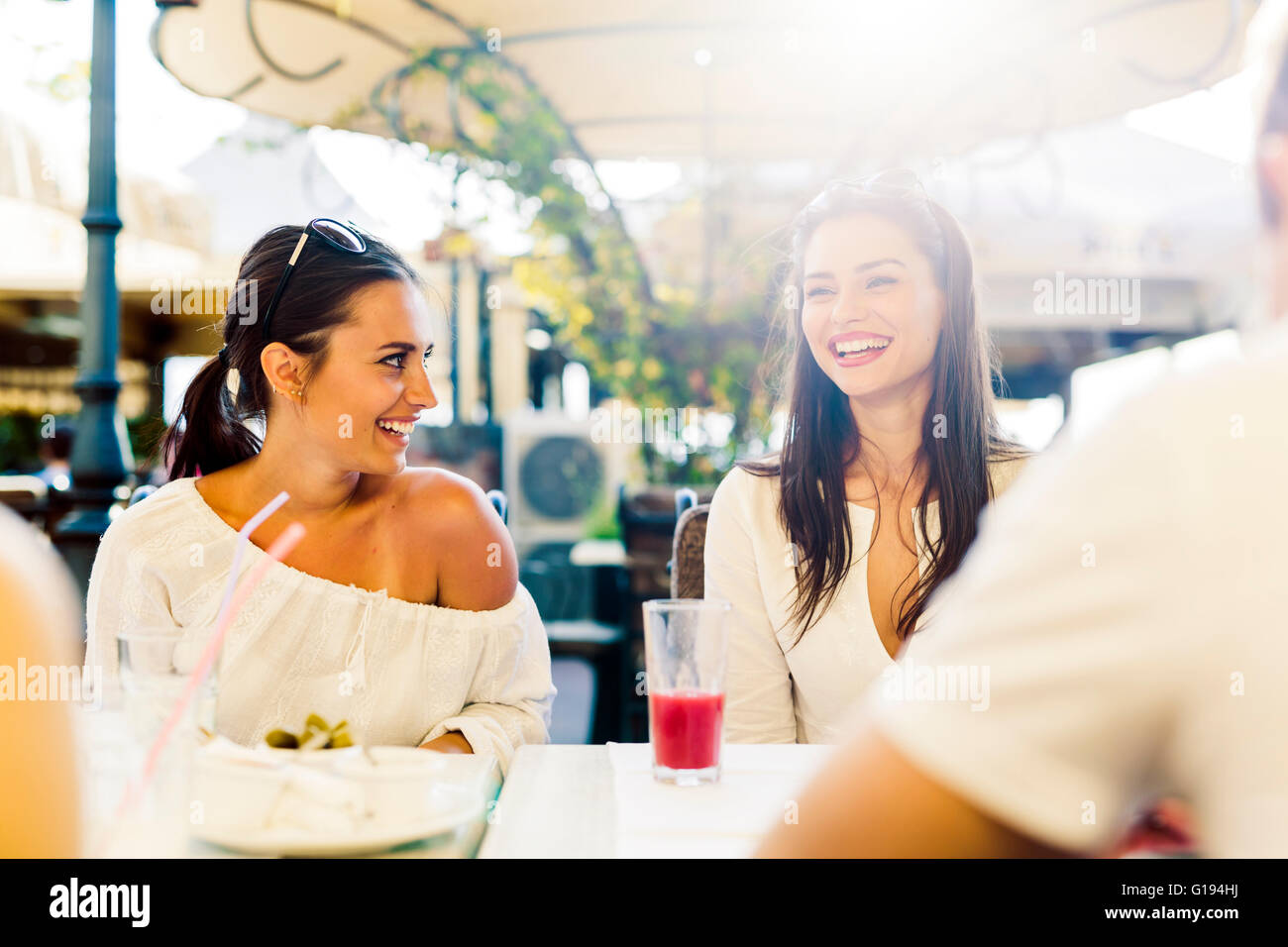 Two young girls talking and smiling during lunch break Stock Photo - Alamy