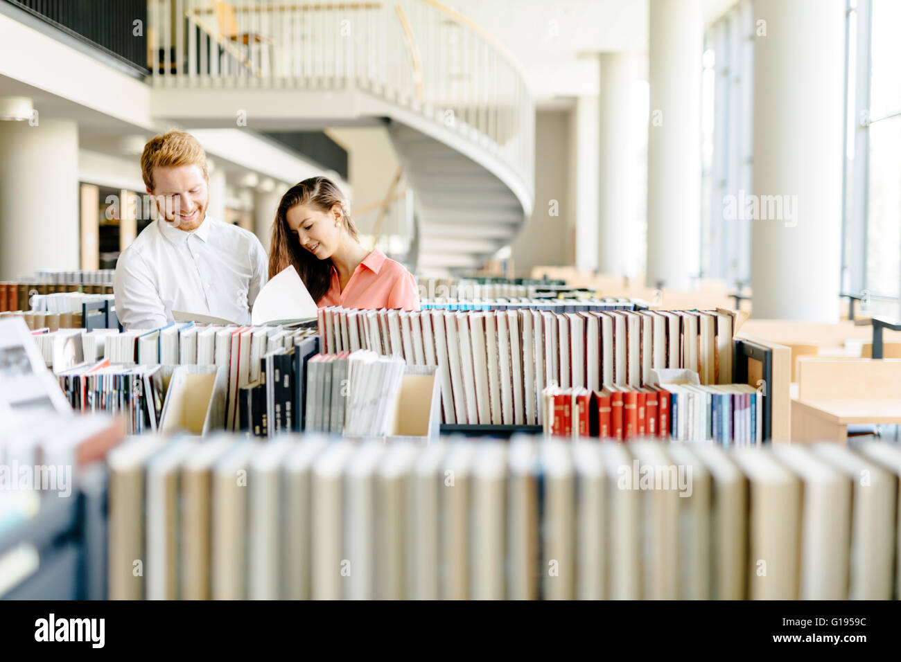 Two smart students reading and studying in library whole searching ...