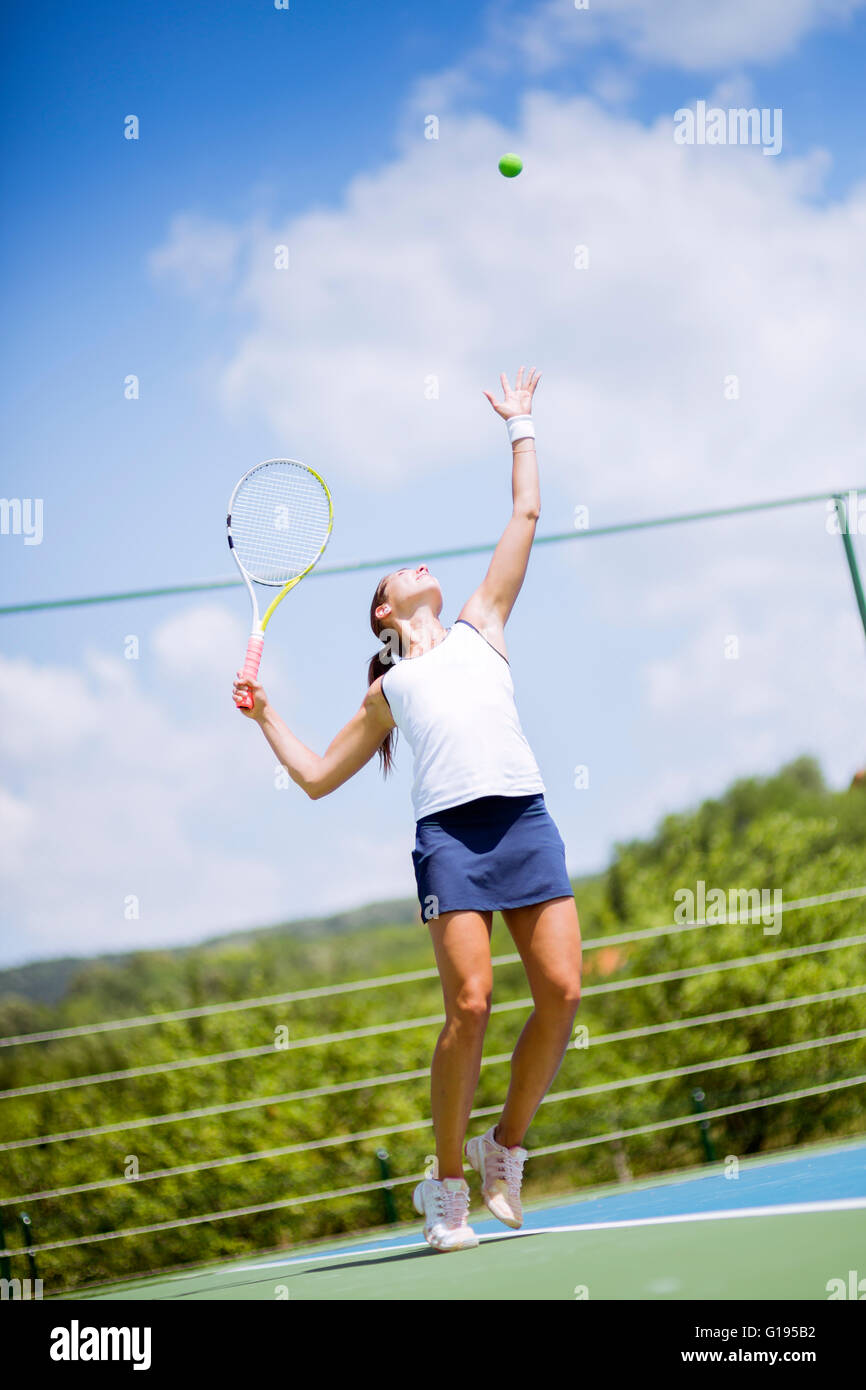 Beautiful female tennis player serving outdoor Stock Photo - Alamy