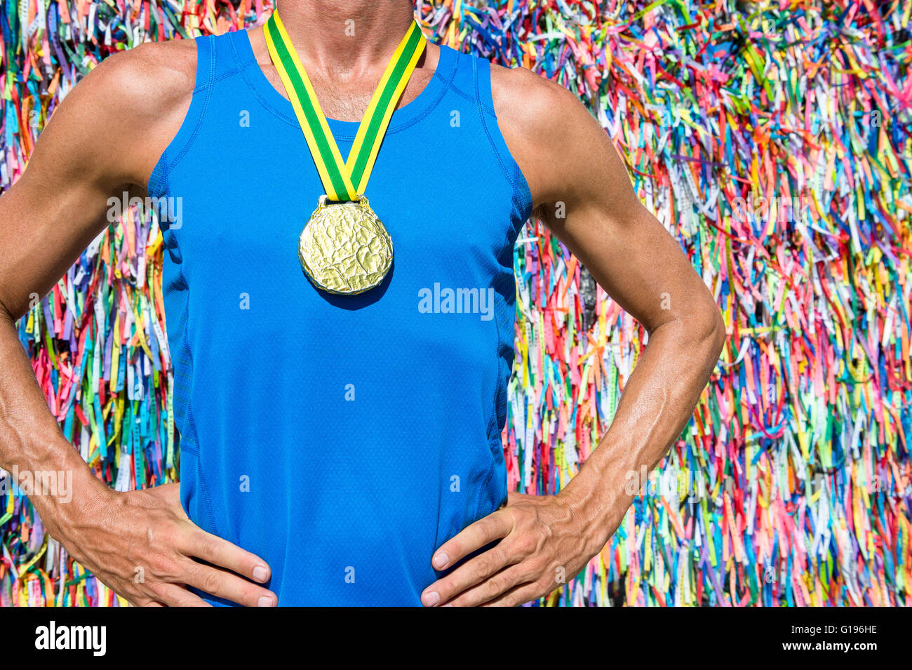 Olympic gold medal athlete stands in front of wall of colorful good ...