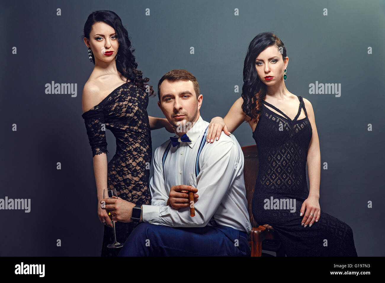 Handsome man surrounded by two beautiful women Stock Photo - Alamy