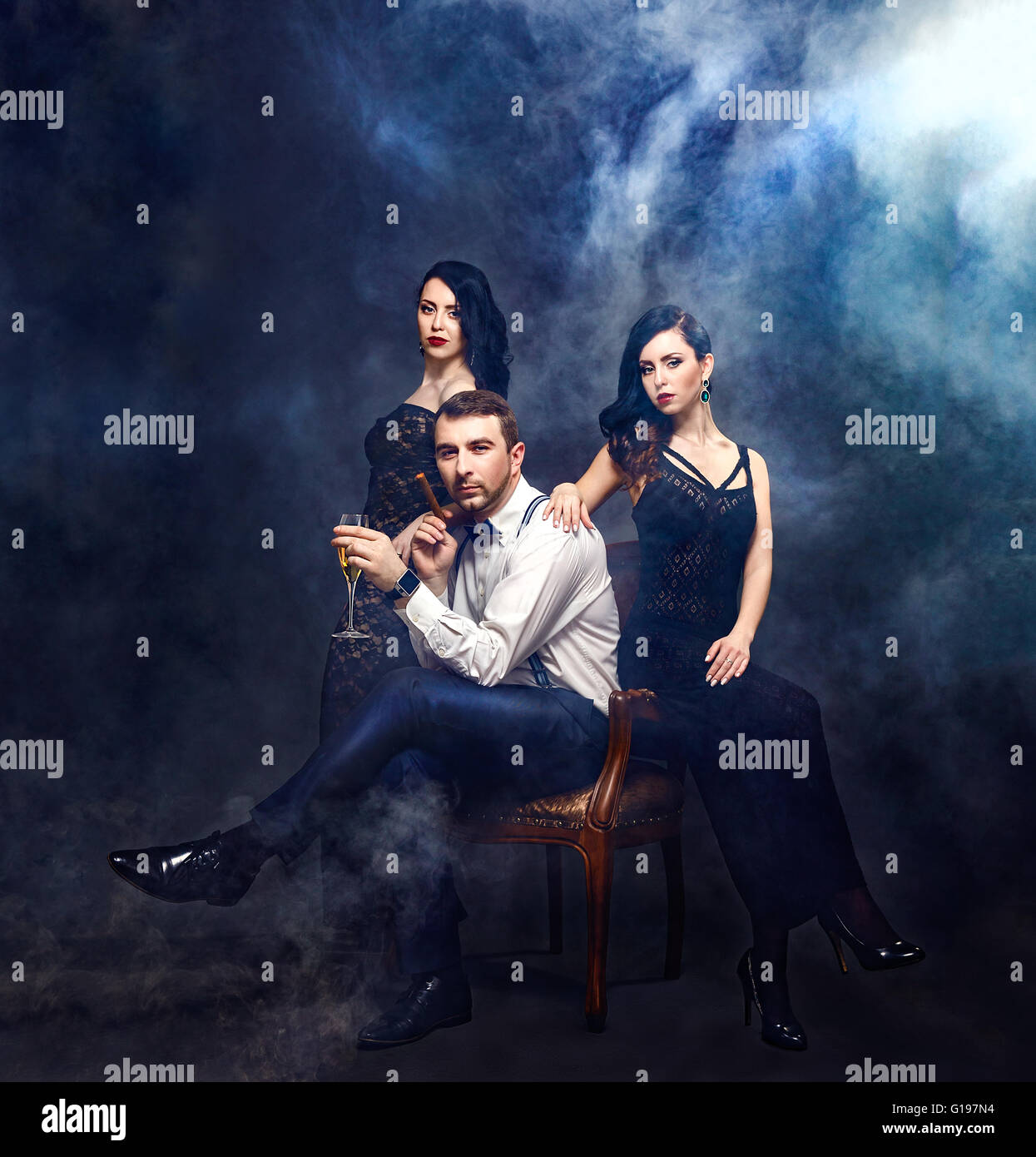 Handsome man surrounded by two beautiful women Stock Photo - Alamy