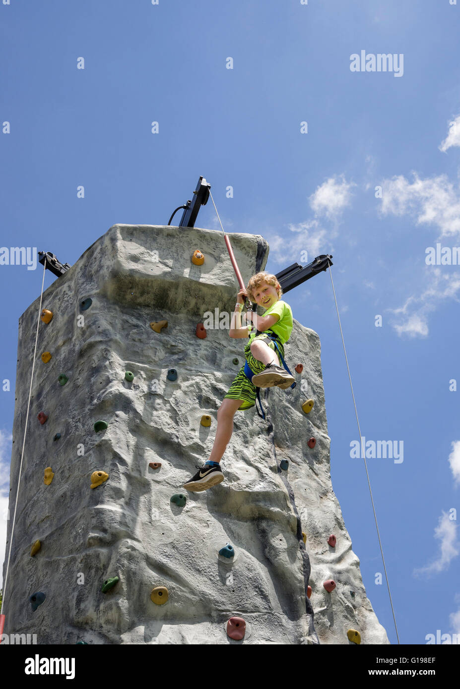 Trying to reach the top of a climbing wall and ring the bell signaling ...