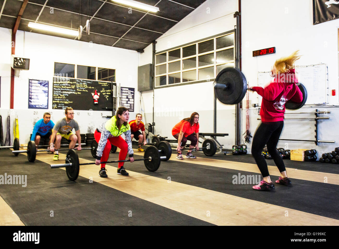 Coach demonstrating a weightlifting movement during a crossfit class ...