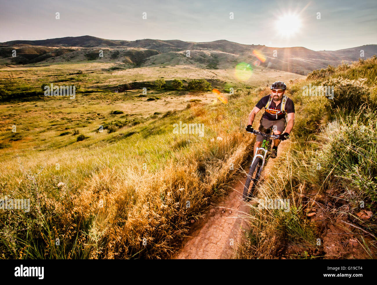 a-male-mountain-biker-rides-on-a-single-track-trail-among-meadows-and