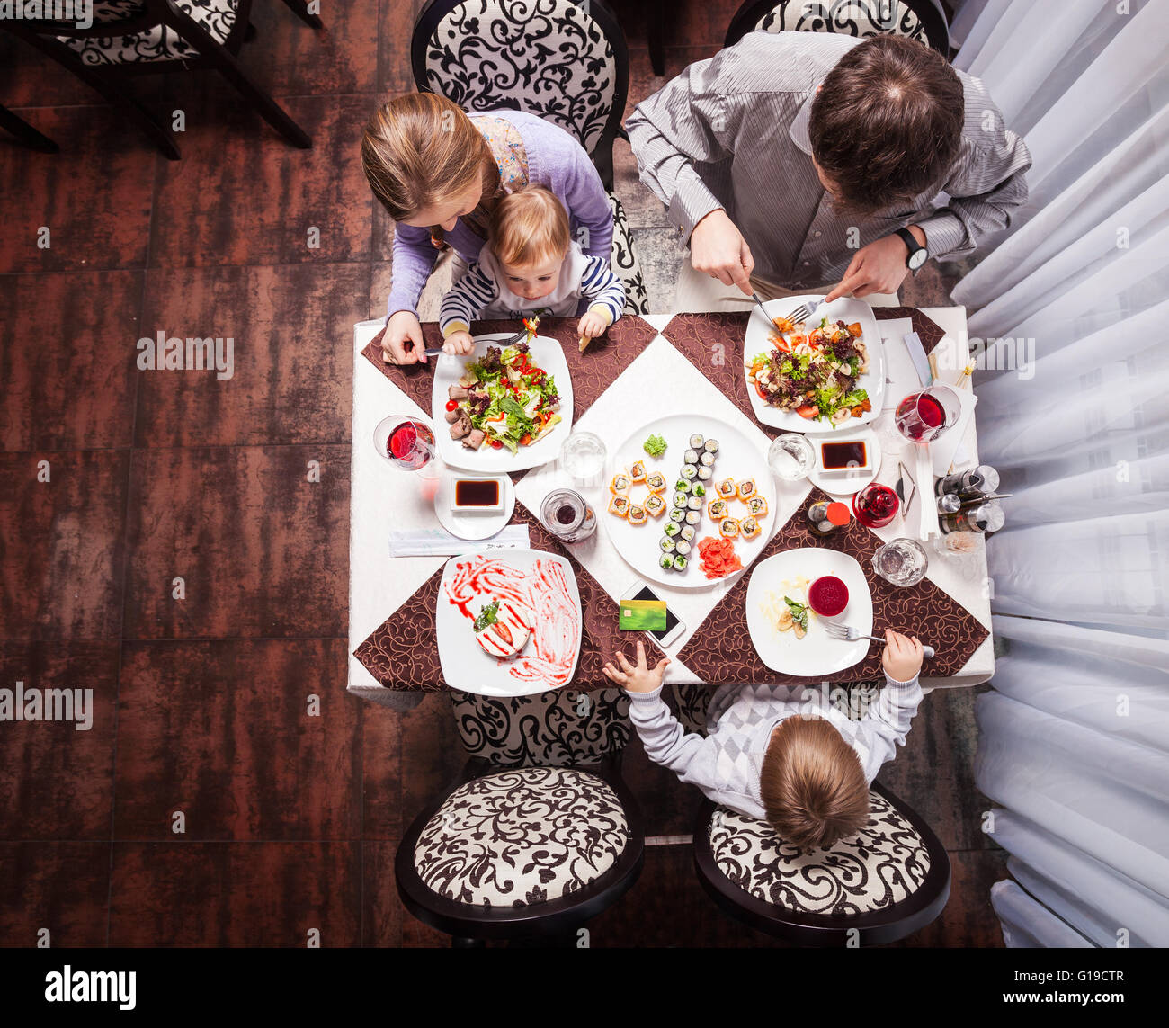 Family of four having meal at a restaurant Stock Photo - Alamy