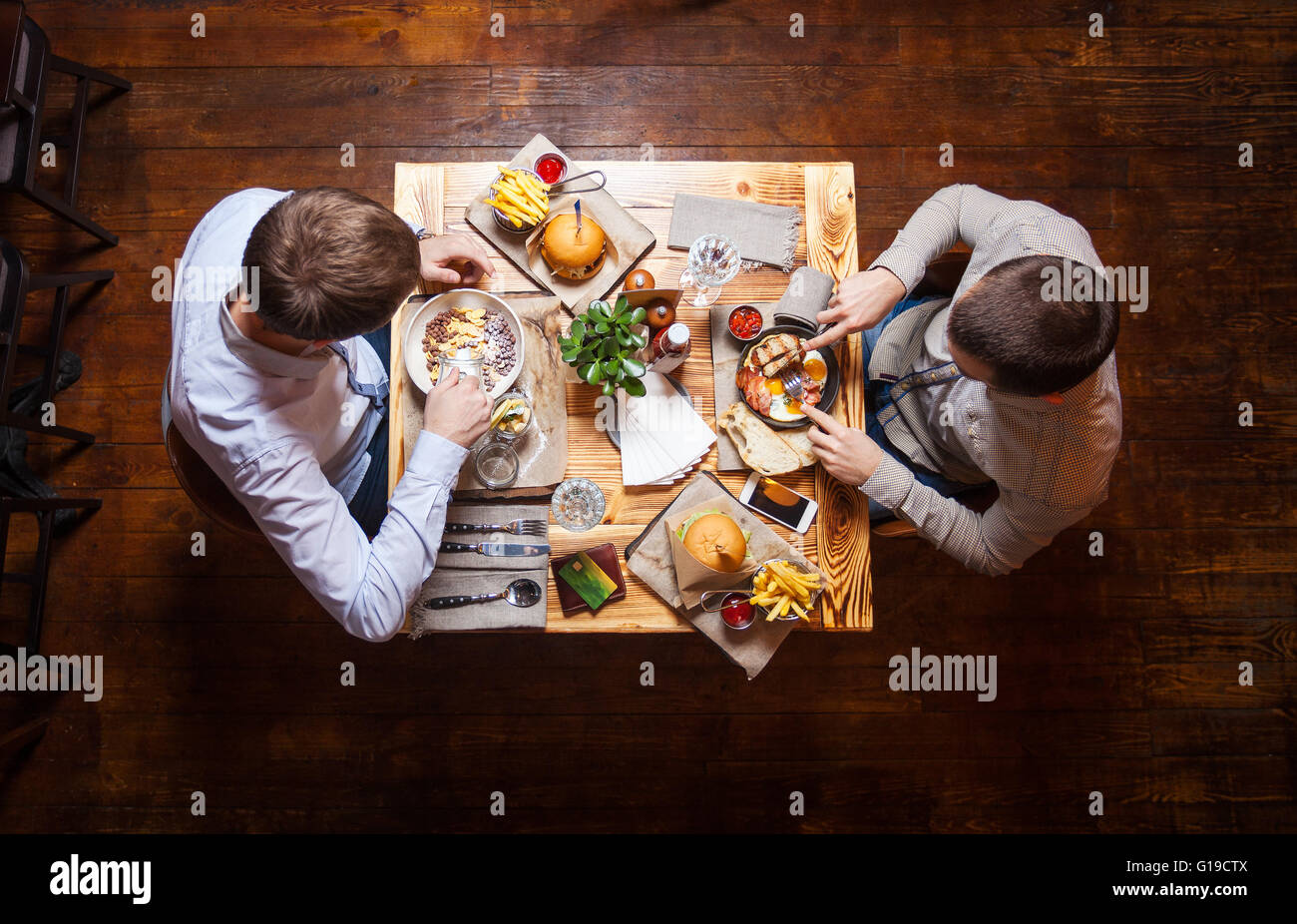 Young men having lunch at a cafe, view from above Stock Photo - Alamy