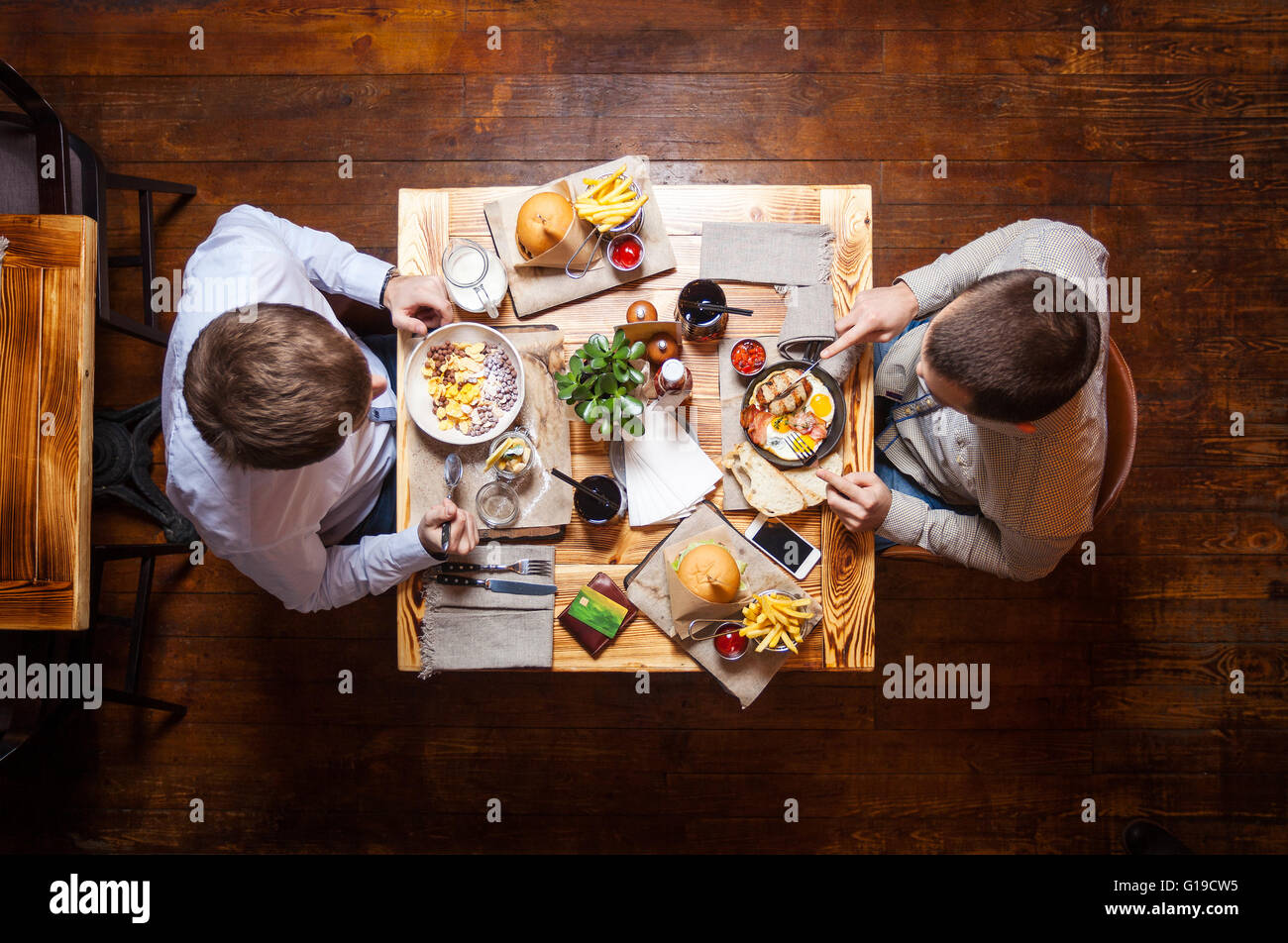 Young men eating out in cafe or restaurant Stock Photo - Alamy