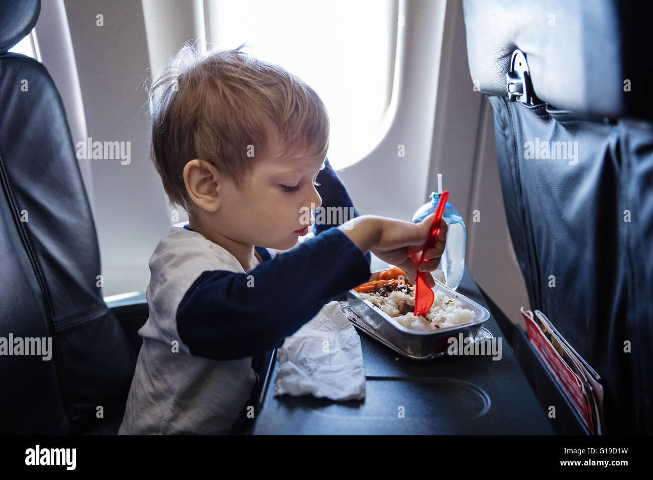 Little boy having a meal on board of a plane Stock Photo - Alamy