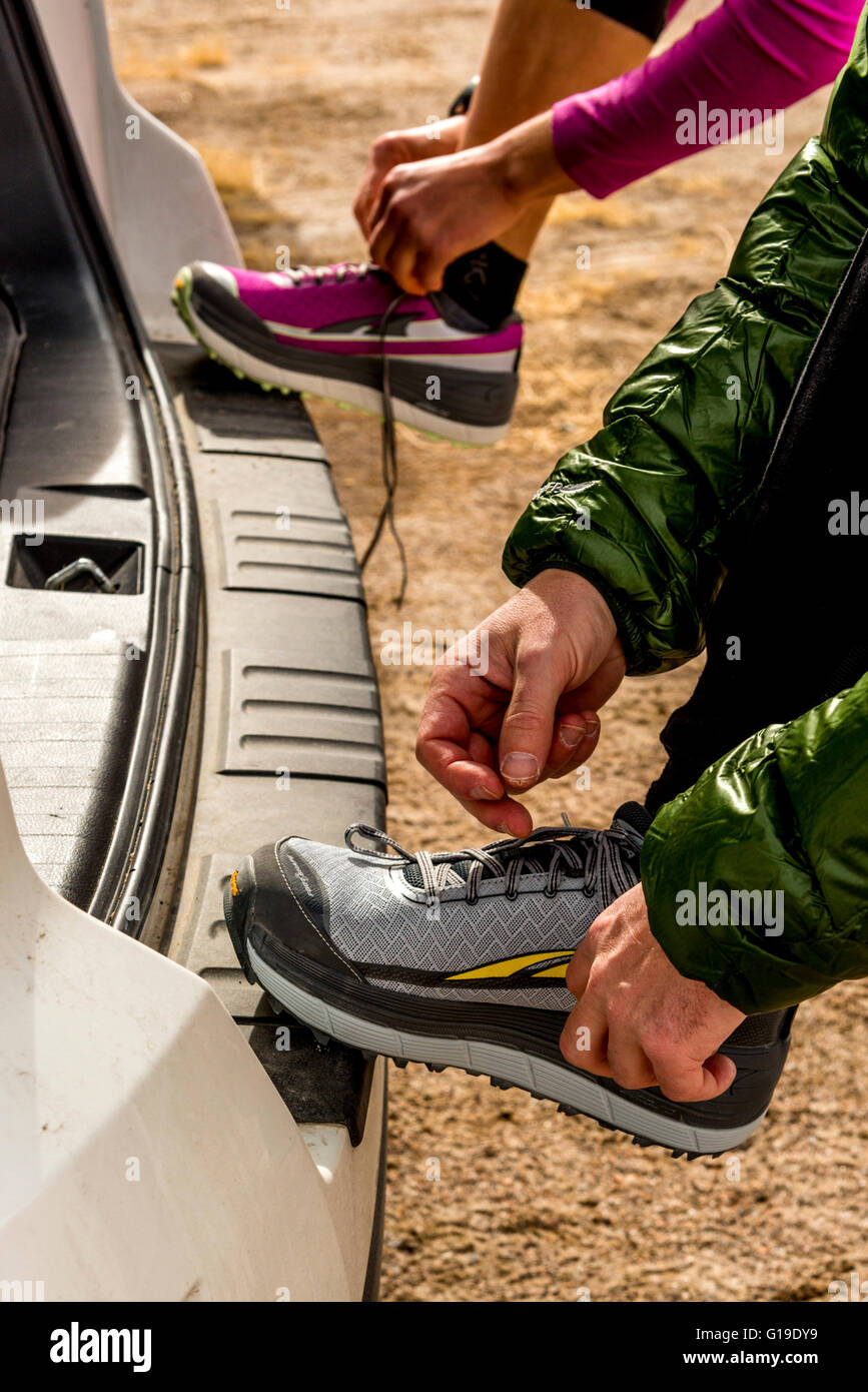 Man and woman putting on shoes Stock Photo - Alamy