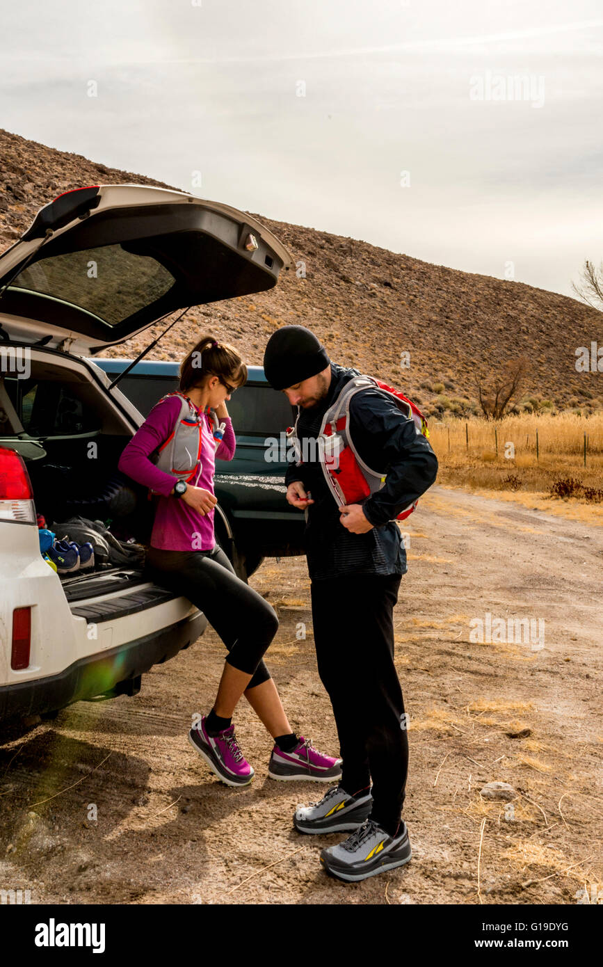 Man and woman putting on packs Stock Photo - Alamy