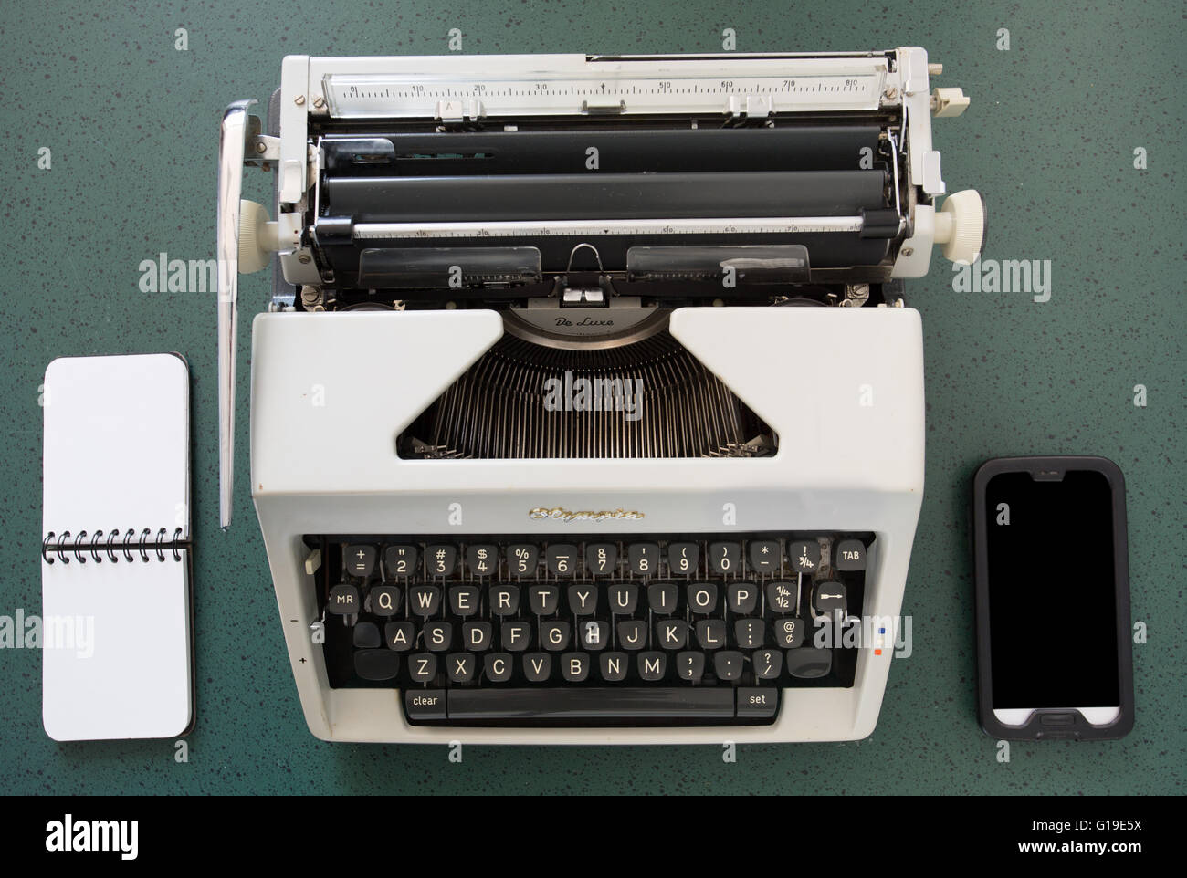 Portable metal typewriter, circa 1970, on a green desk with a ...