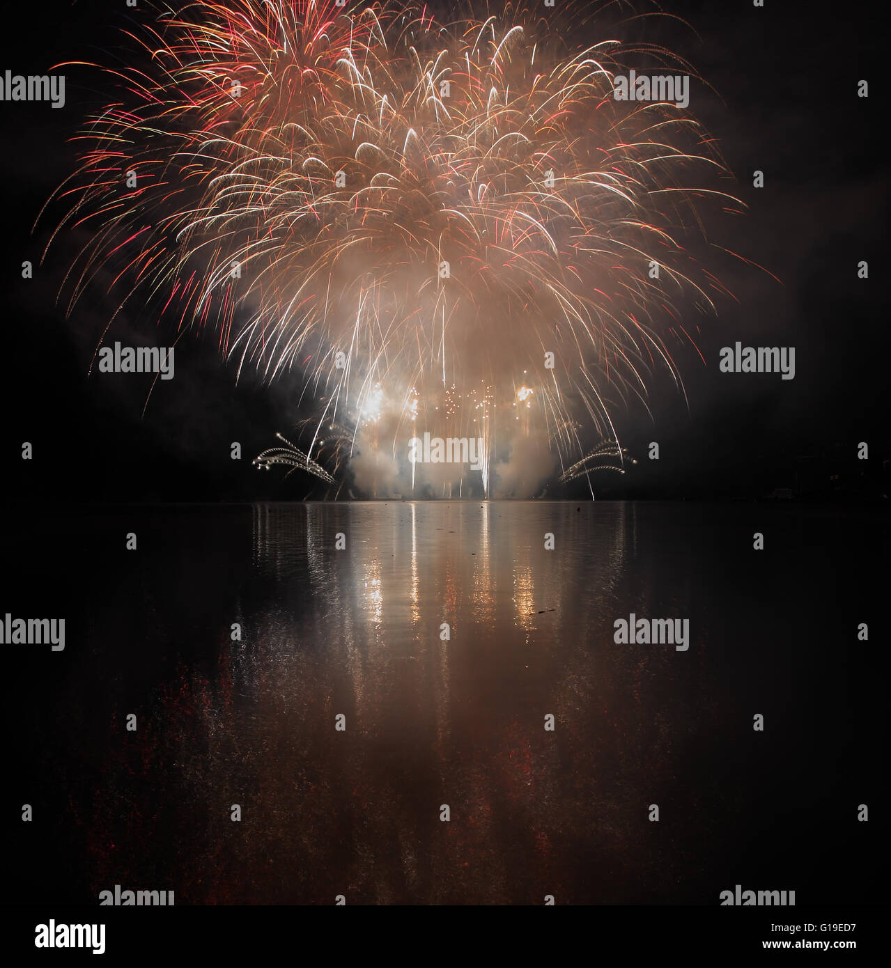 Colorful fireworks with reflection on lake and night sky in background ...