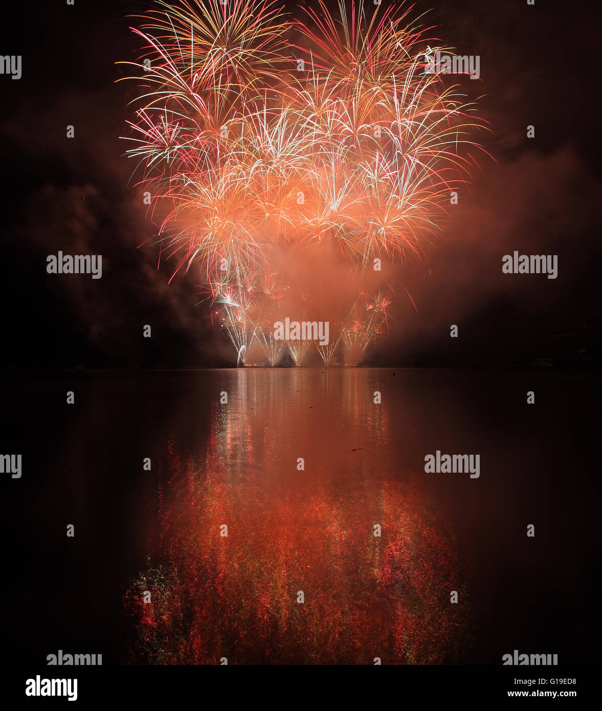 Colorful fireworks with reflection on lake and night sky in background ...