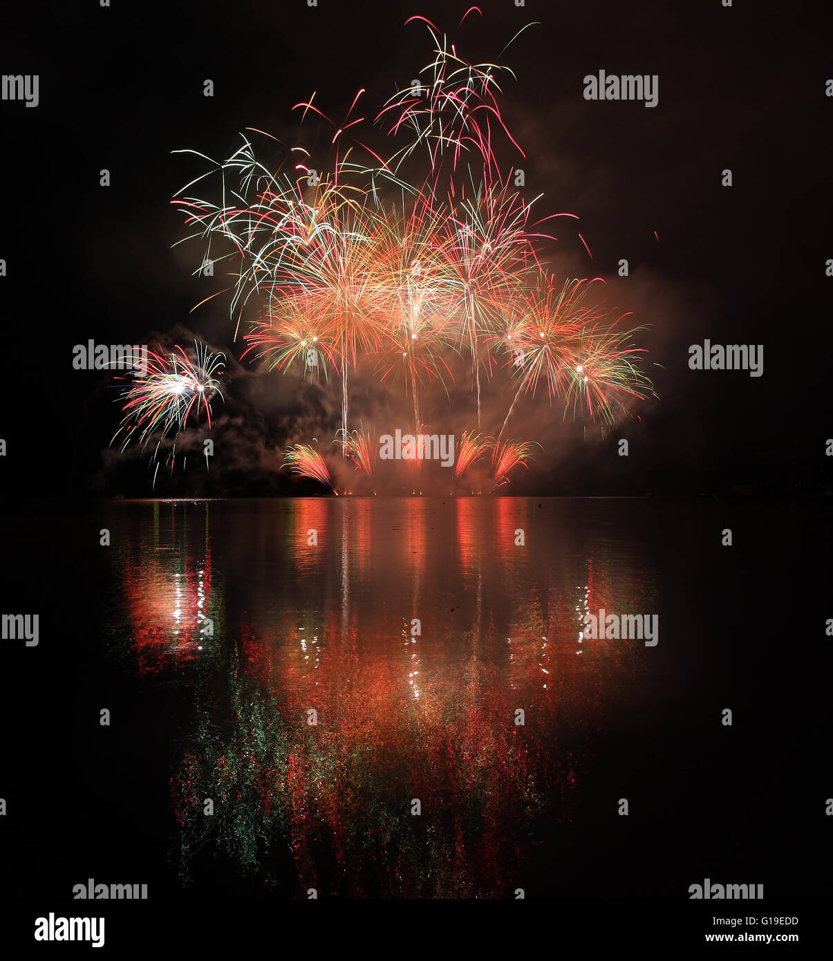 Colorful fireworks with reflection on lake and night sky in background ...
