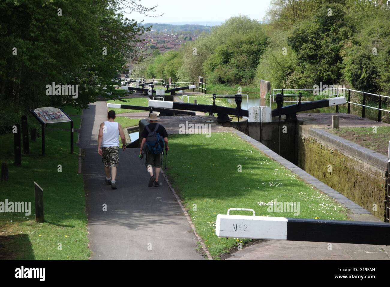 Two people walking along the towpath at the top of Delph Locks on the ...