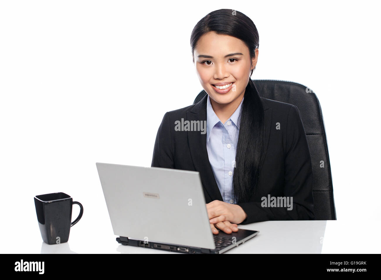 Successful Asian Businesswoman Seated At Her Desk With Her Laptop And A