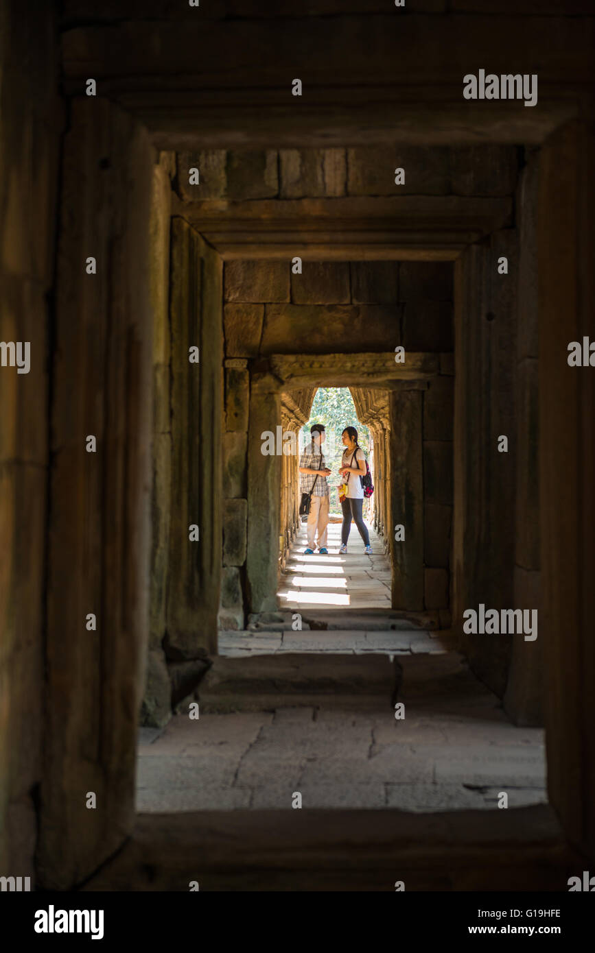 Two tourist at the end of a passage visiting the Angkor Wat temple ...
