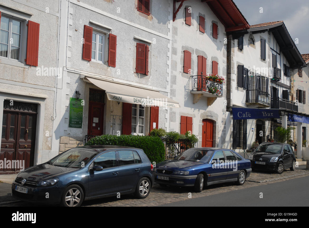 Village street scene with parked cars showing traditional architecture ...